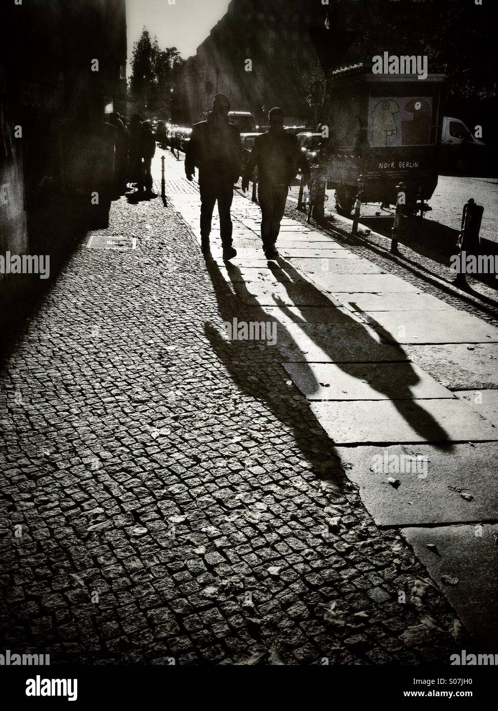 Backlit men and their shadows, walking toward the photographer Stock ...