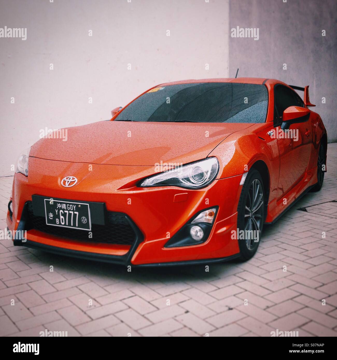 Bright red Toyota sports car parked on a sidewalk in central Manila ...