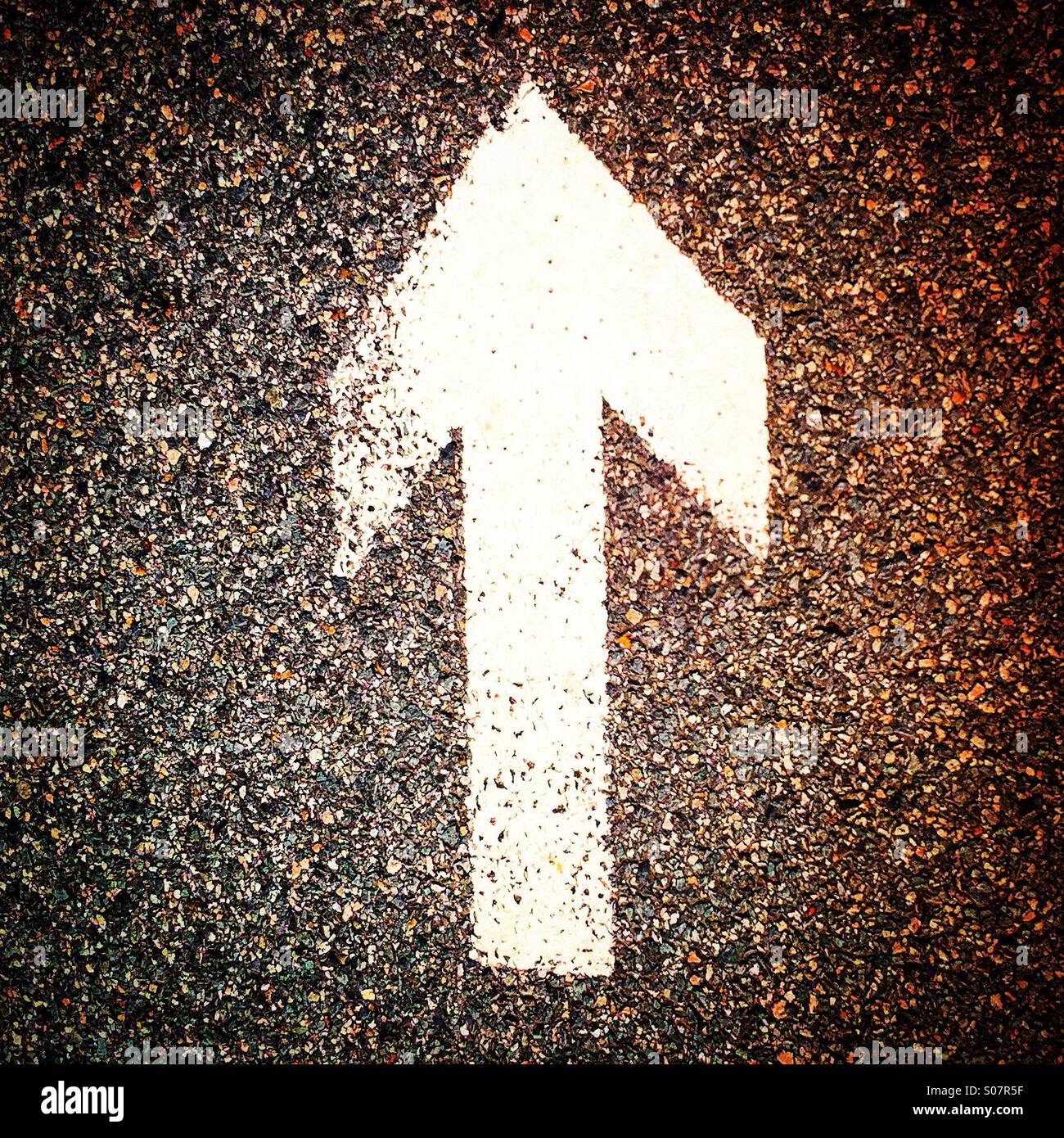 White arrow on the road showing going straight Stock Photo - Alamy