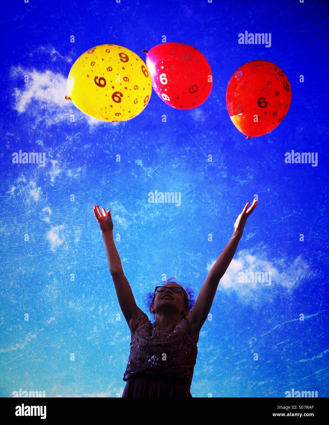 Young girl throwing party balloons up into the air Stock Photo - Alamy
