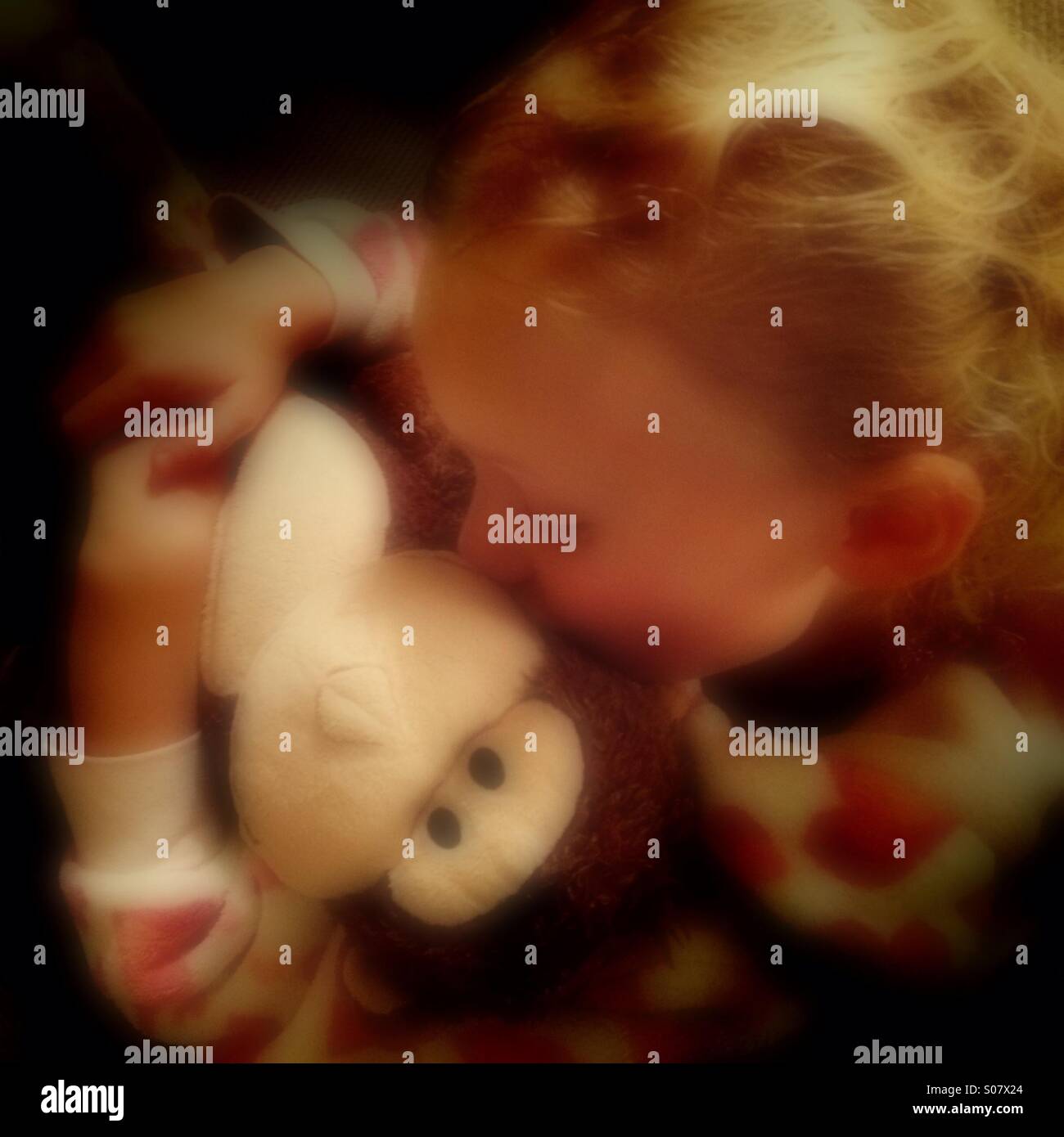 Young girl cuddling soft toy Stock Photo - Alamy