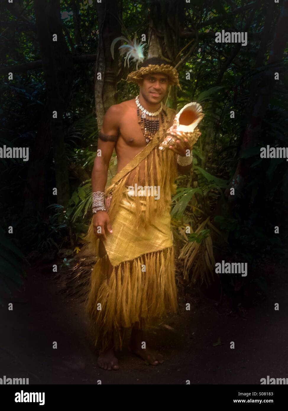 Native warrior in Vanuatu in traditional dress holding a Conch shell ...