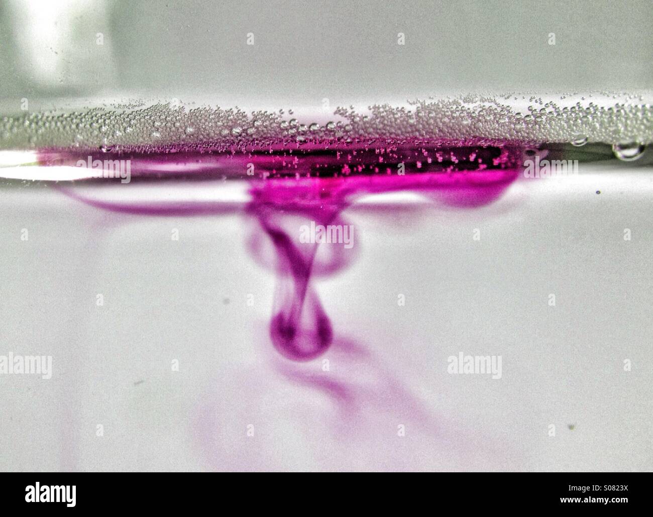 Coloured water mixing with clear water Stock Photo - Alamy