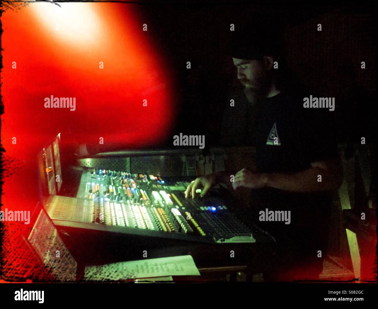 Sound engineer at work behind a mixing table during a live concert ...