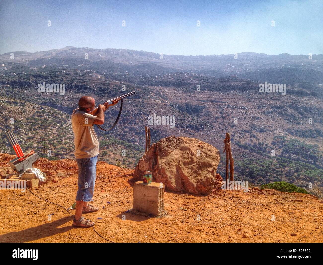Middle aged man shooting tyro in the mountains Stock Photo - Alamy