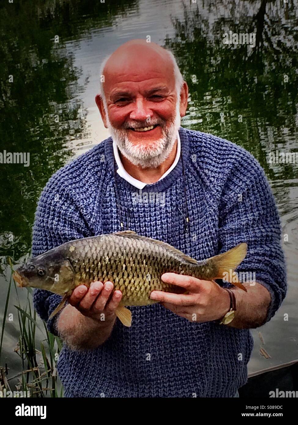 Happy angler with catch of the day, common carp Stock Photo - Alamy