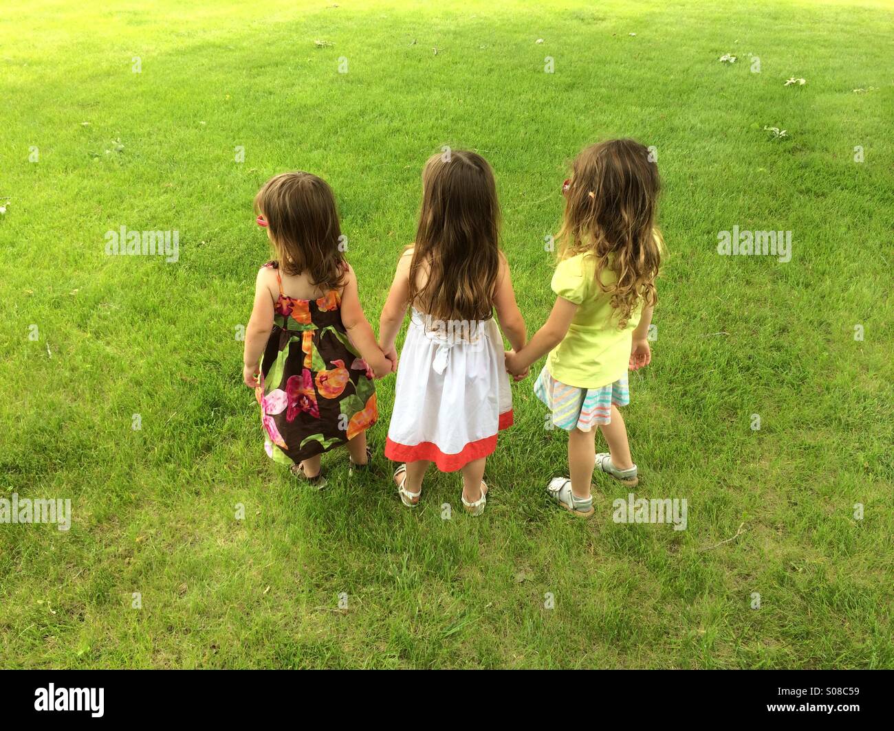 Three girls holding hands hi-res stock photography and images - Alamy