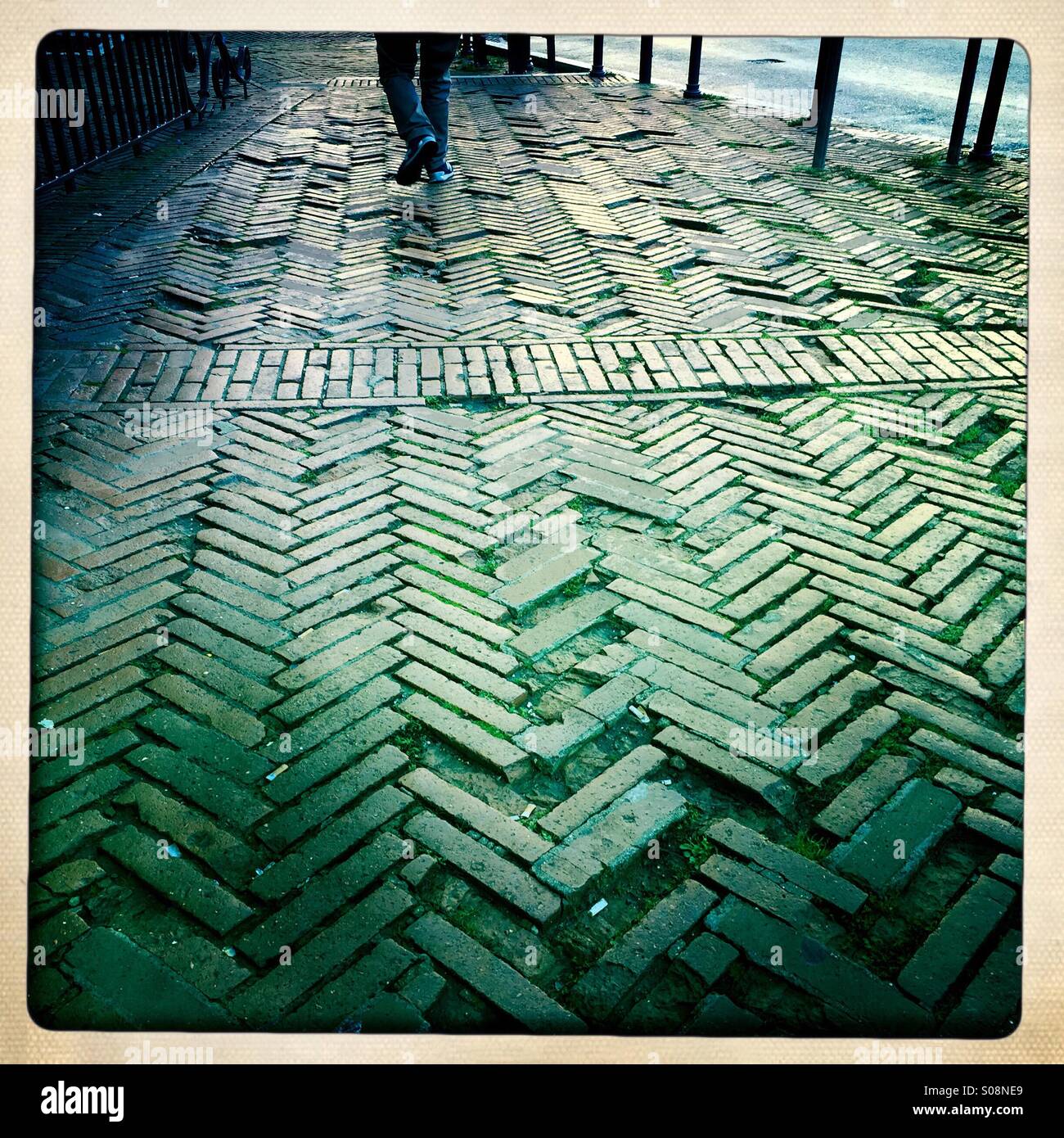 Man walking on an old bricks ground in Italy Stock Photo - Alamy