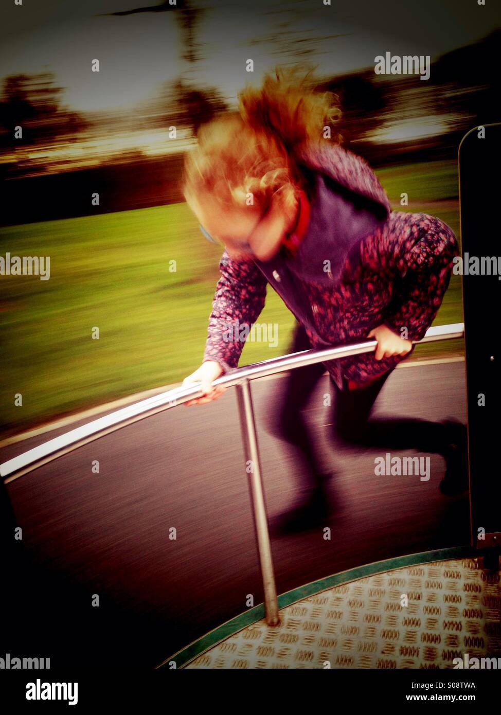 Young girl running around with roundabout on playground Stock Photo - Alamy