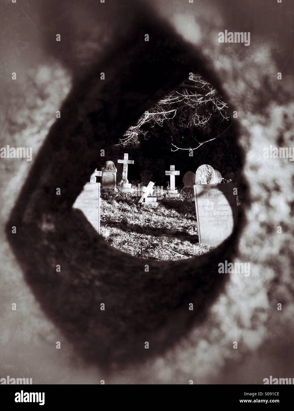 Village graveyard viewed through hole in stone tombstone. Caythorpe ...