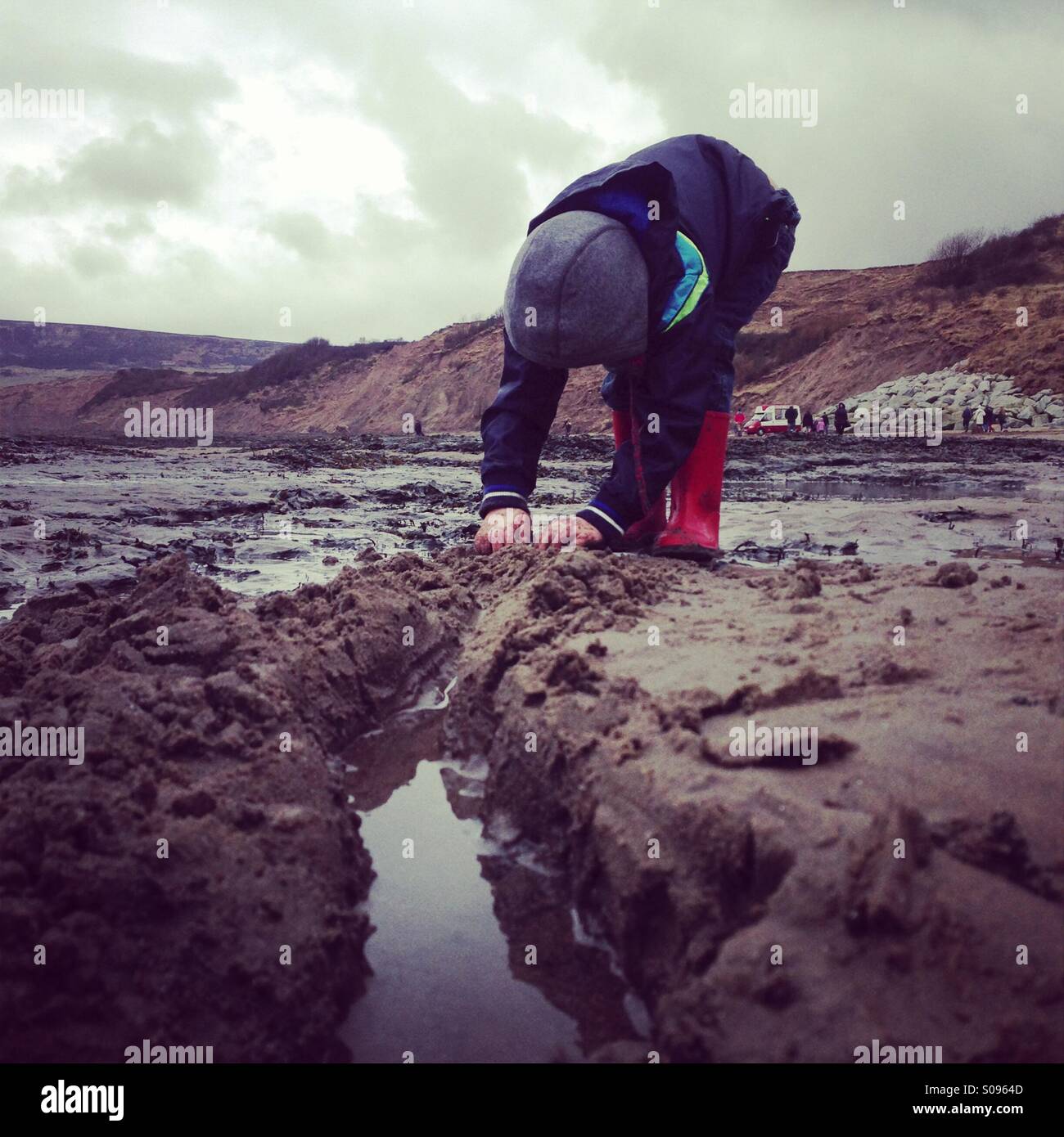 Boy digging on beach Stock Photo - Alamy
