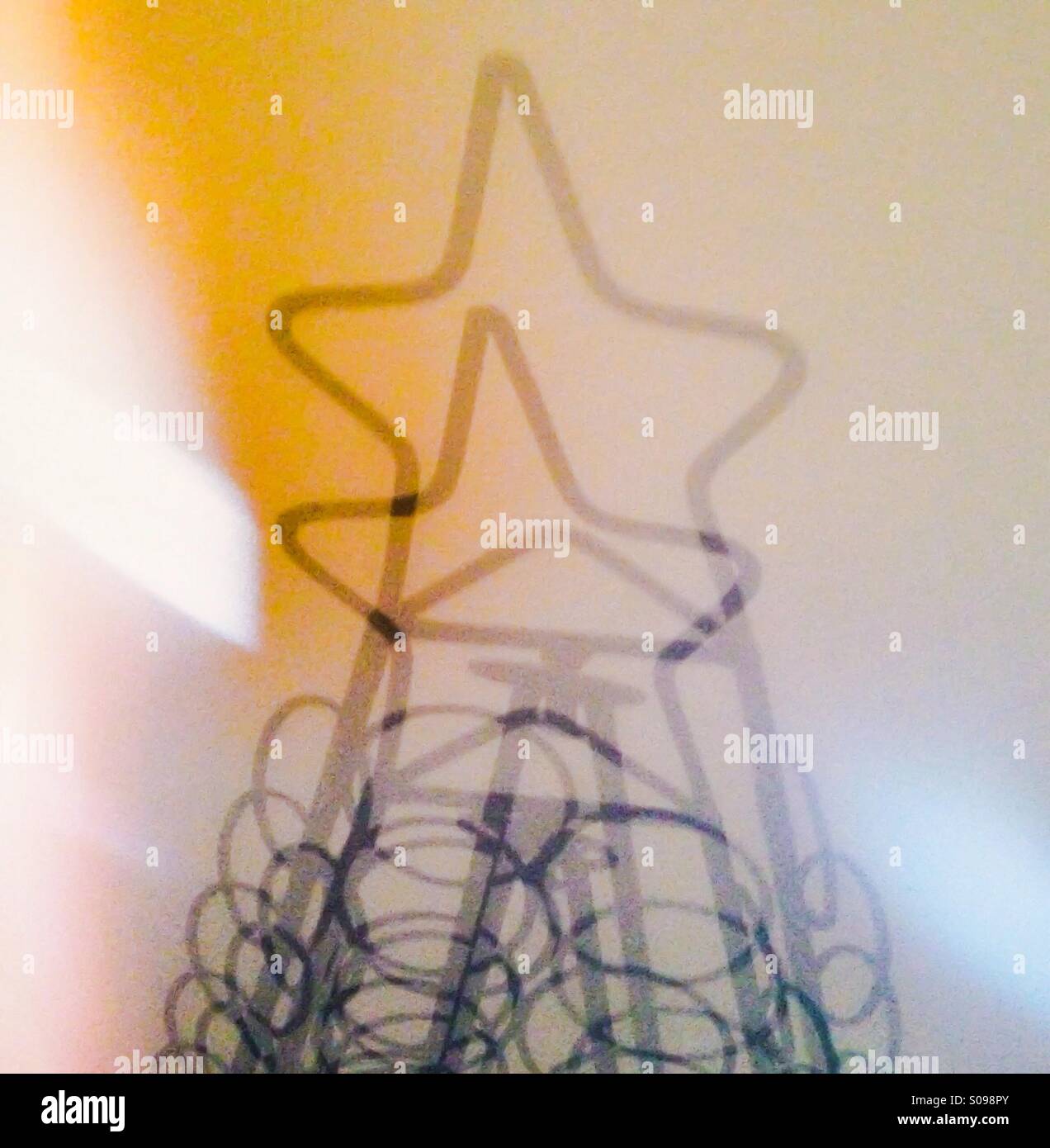 Shadows of a star topped metal tree decoration Stock Photo - Alamy