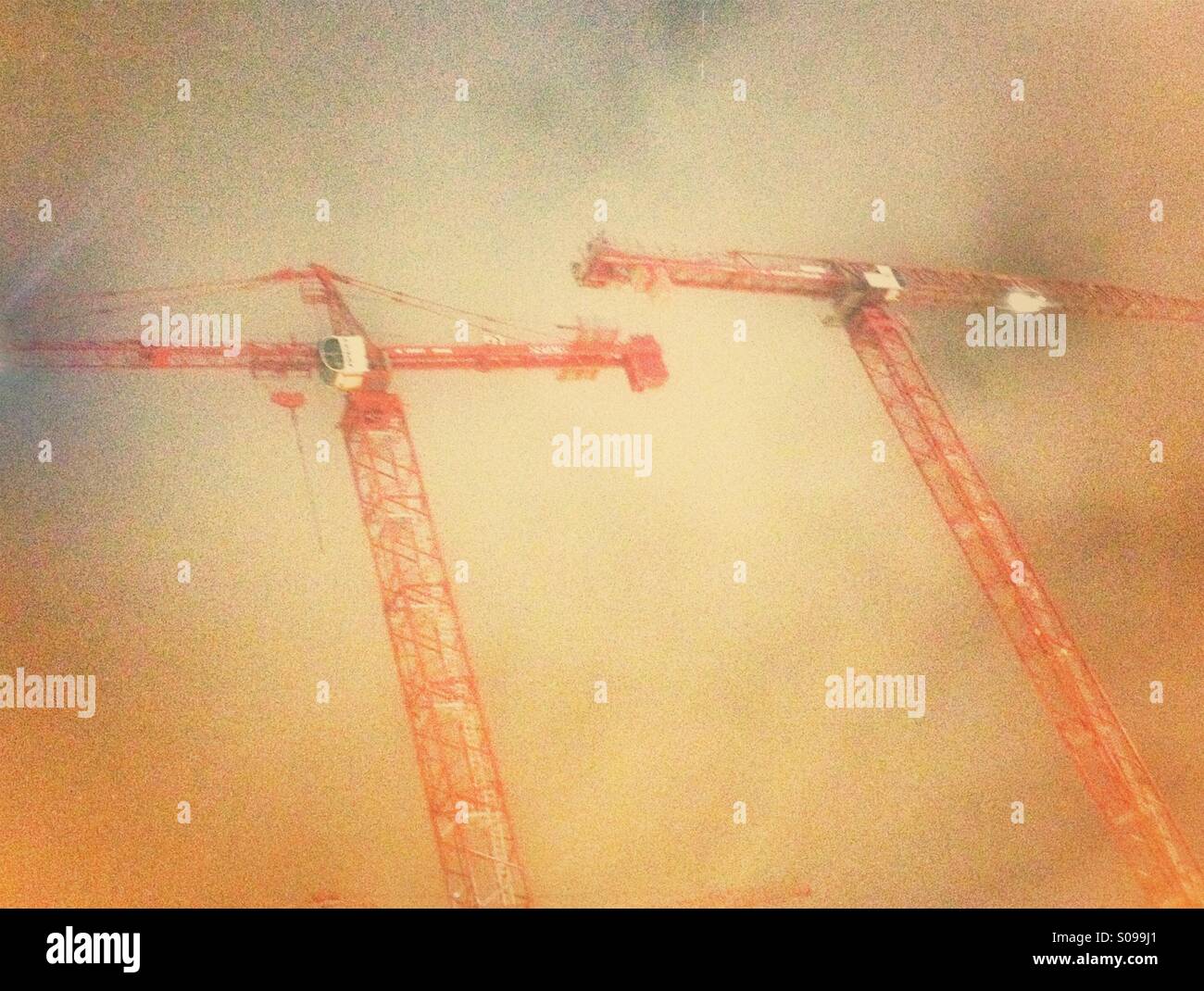 Two construction derricks (cranes Stock Photo - Alamy
