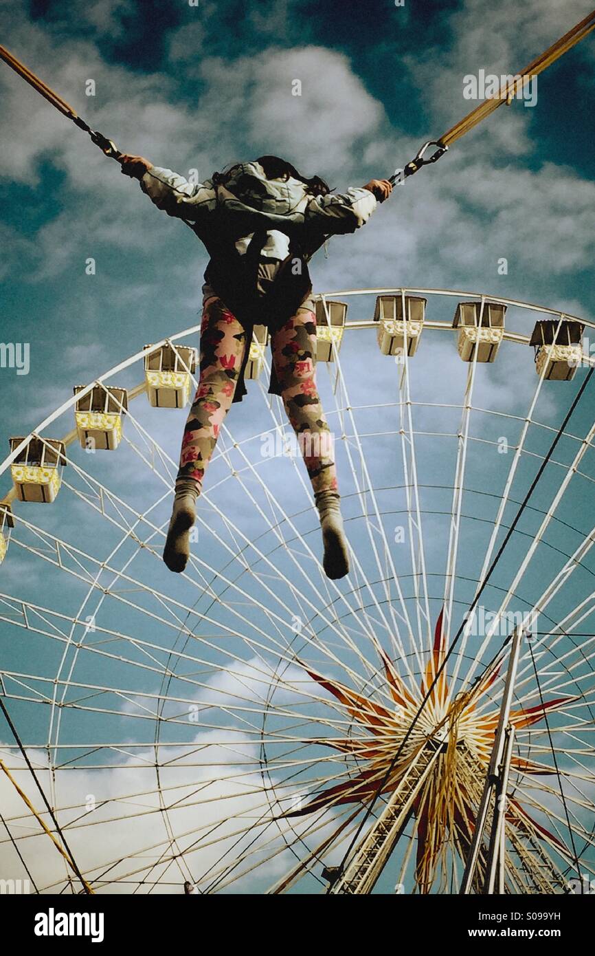 Girl hanging on a bungee cord on a trampoline Stock Photo - Alamy