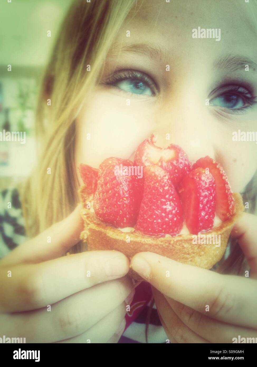 Young girl eating a strawberry cake Stock Photo - Alamy