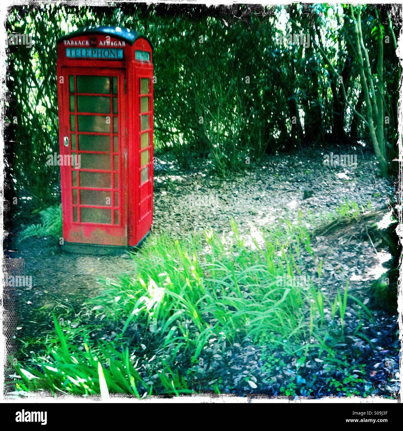 Red phone box in a garden Stock Photo - Alamy