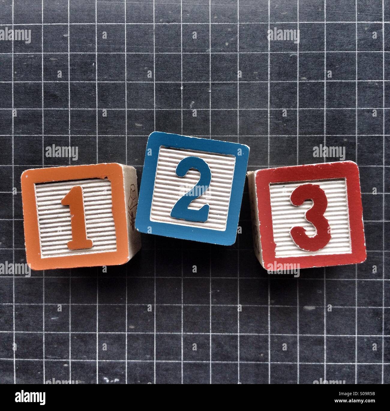 One,Two,Three wooden toy blocks on a grid pattern background Stock ...