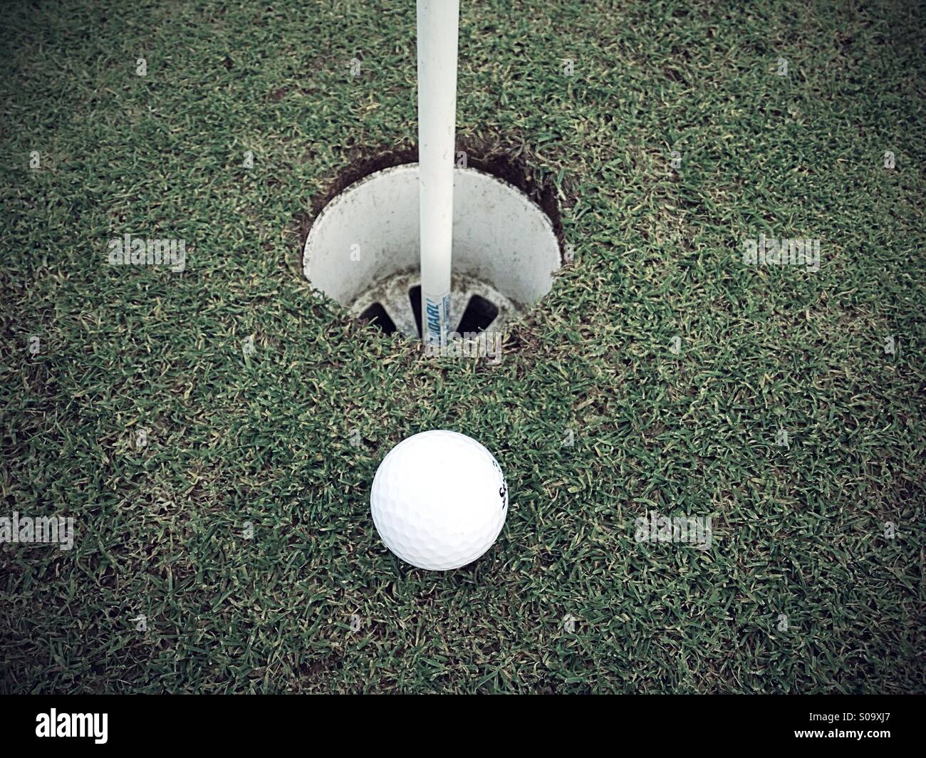 Golf ball near to hole Stock Photo - Alamy