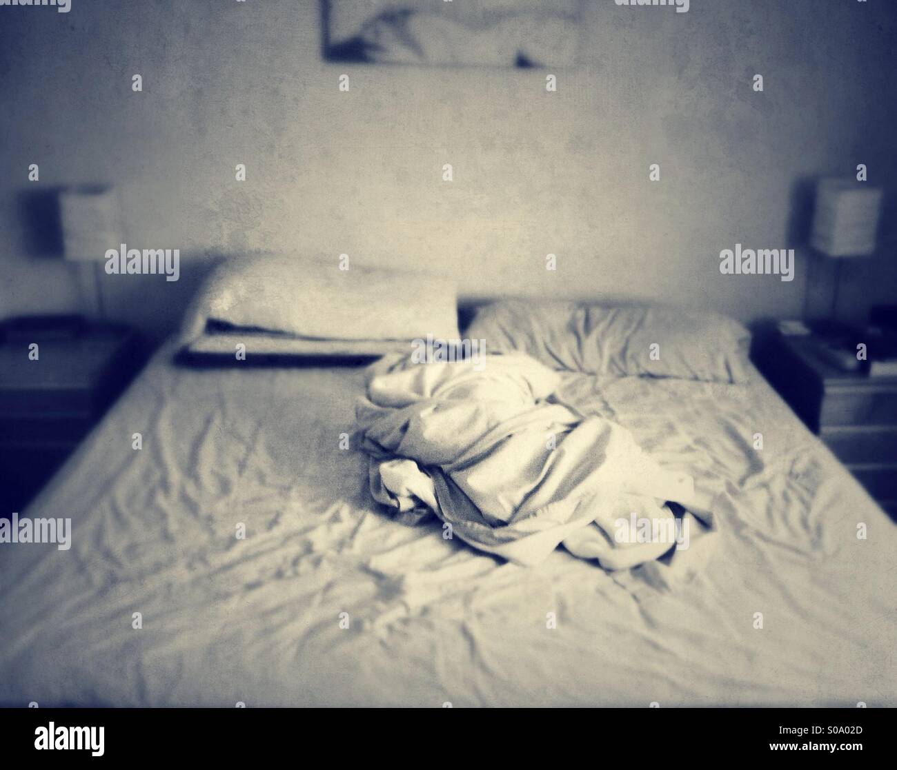 Empty lonely bed with balled up covers Stock Photo - Alamy