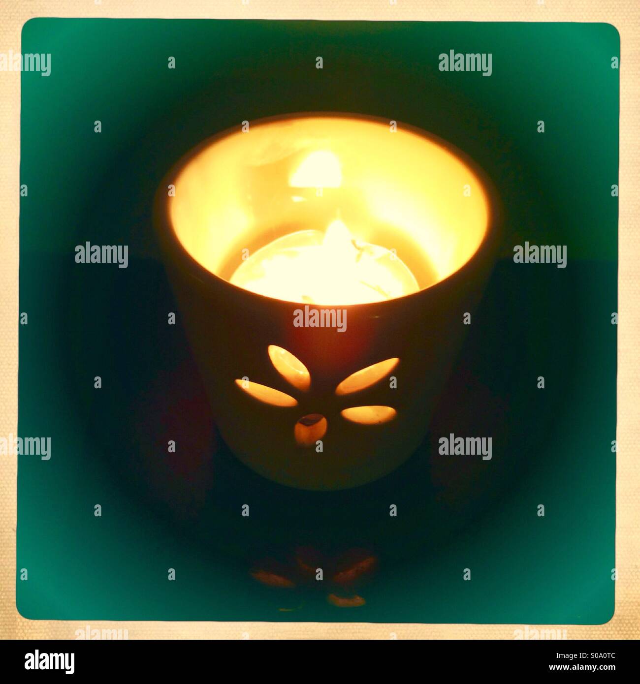 Tea light candle with shadows Stock Photo - Alamy