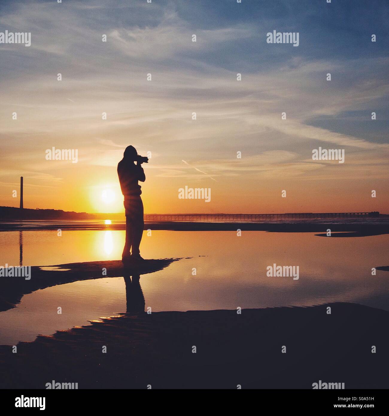A photographer stand on the beach in Hartlepool, UK to take a picture ...