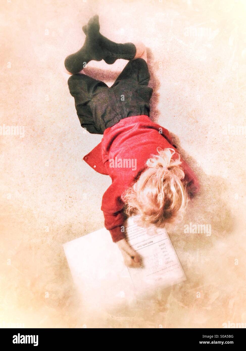 Young girl doing her spelling homework lying on the carpet Stock Photo ...