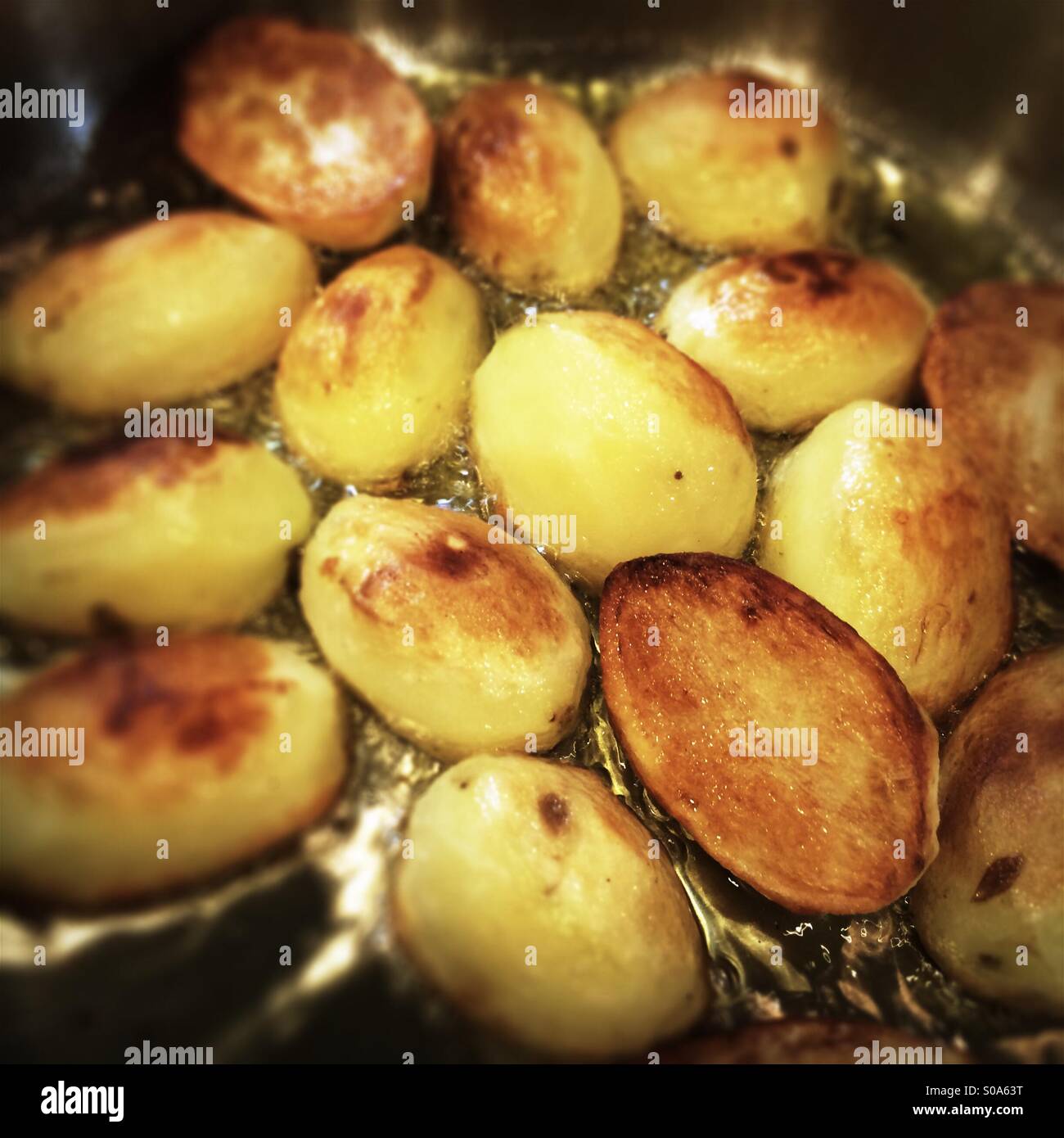 Golden brown potatoes roasting and sizzling in a pan Stock Photo - Alamy