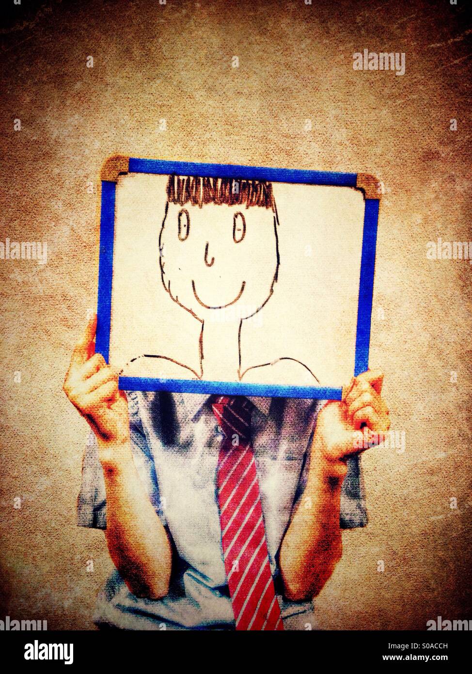 Young girl holding up white board with cartoon face in front of her ...