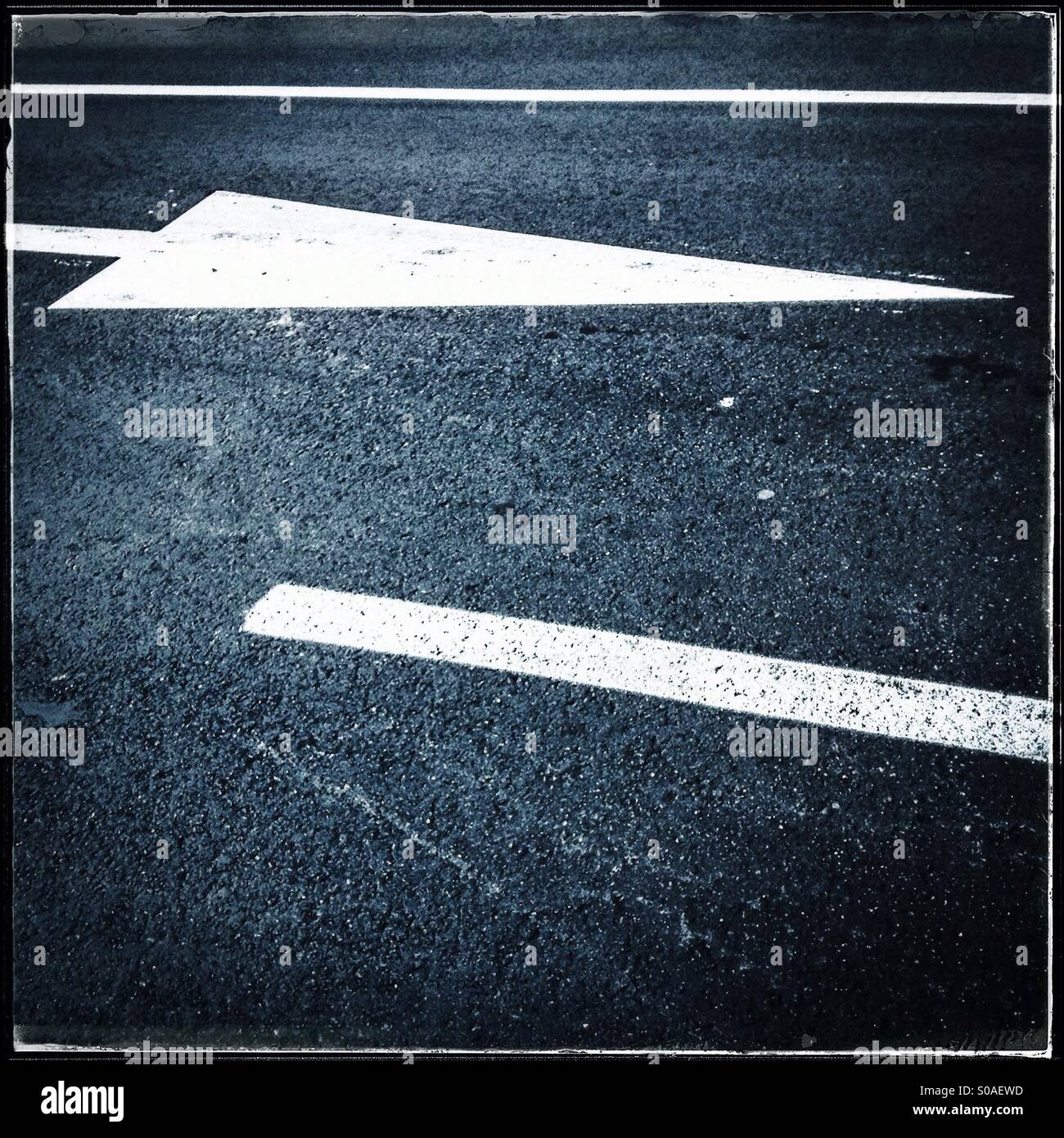 White arrow sign painted on asphalt Stock Photo - Alamy