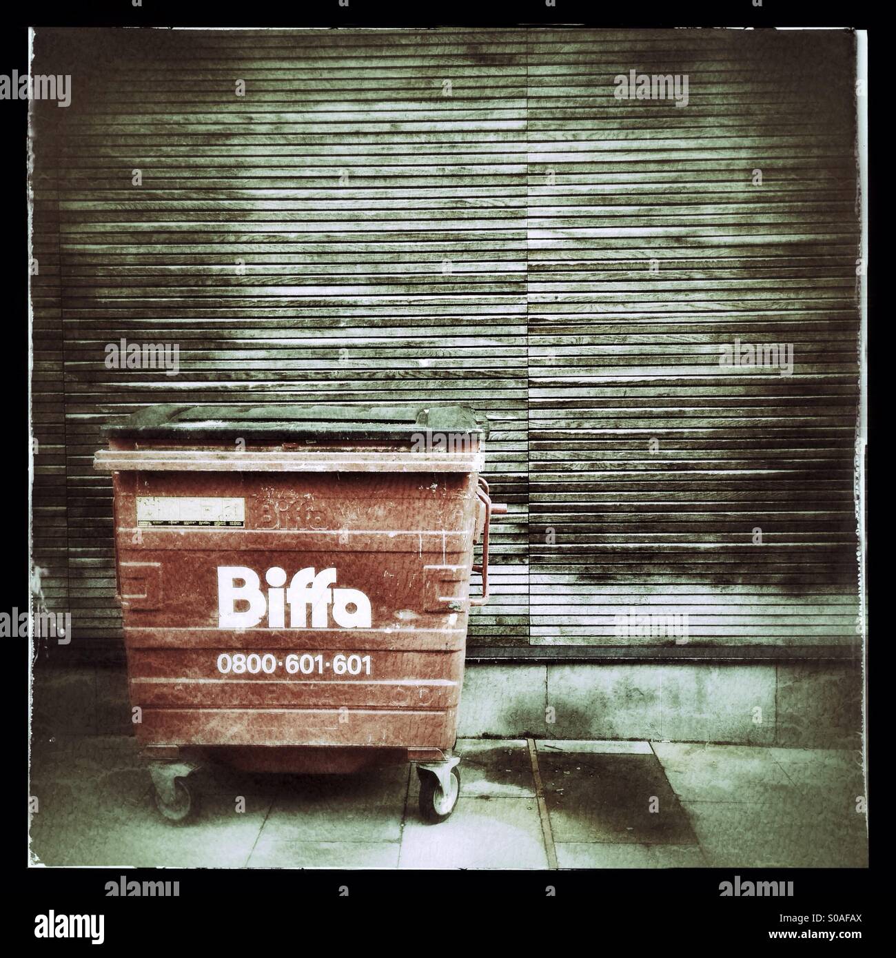 Wheeled refuse container against a slatted wooden background Stock ...