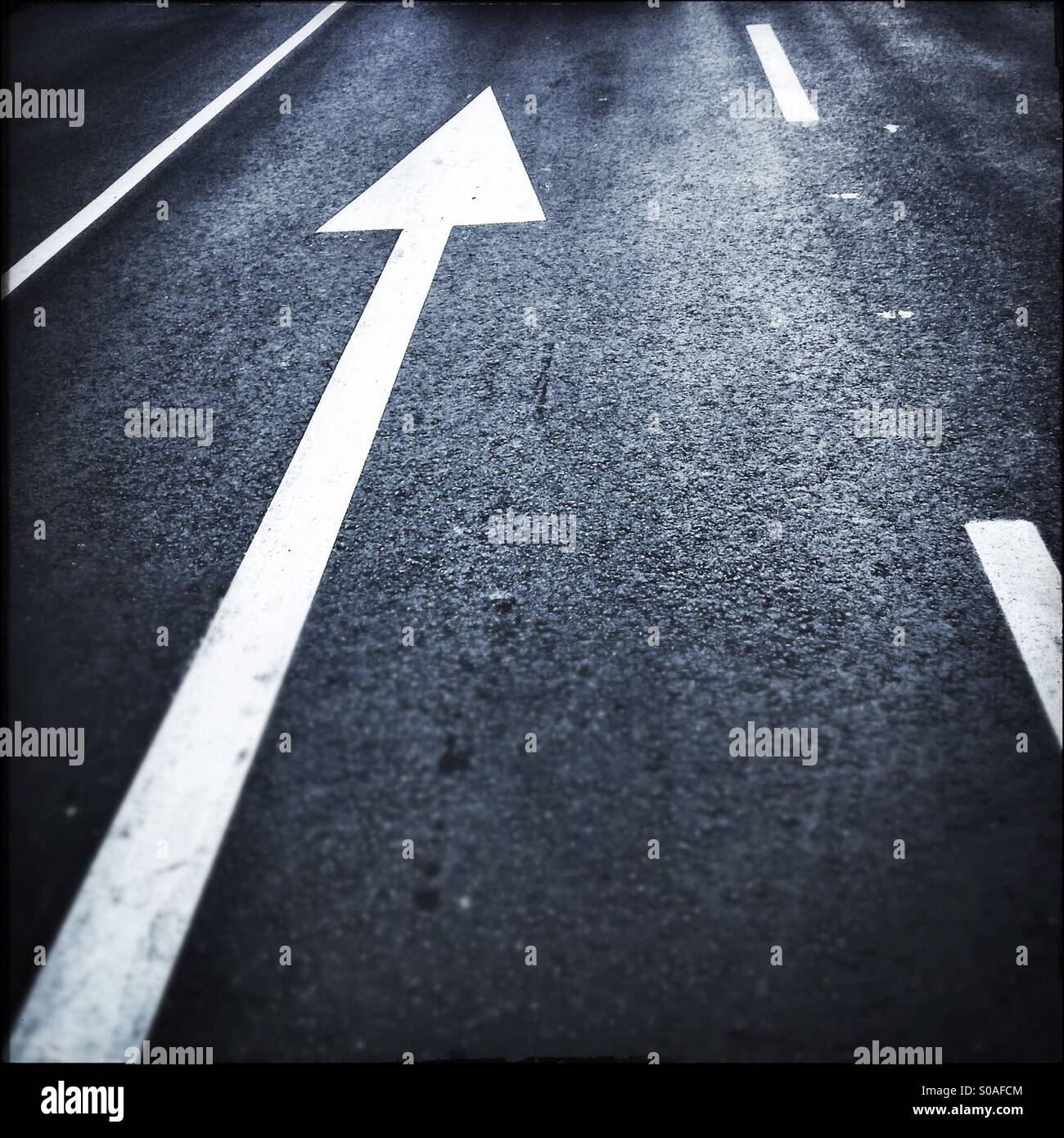 White arrow sign on asphalt Stock Photo - Alamy