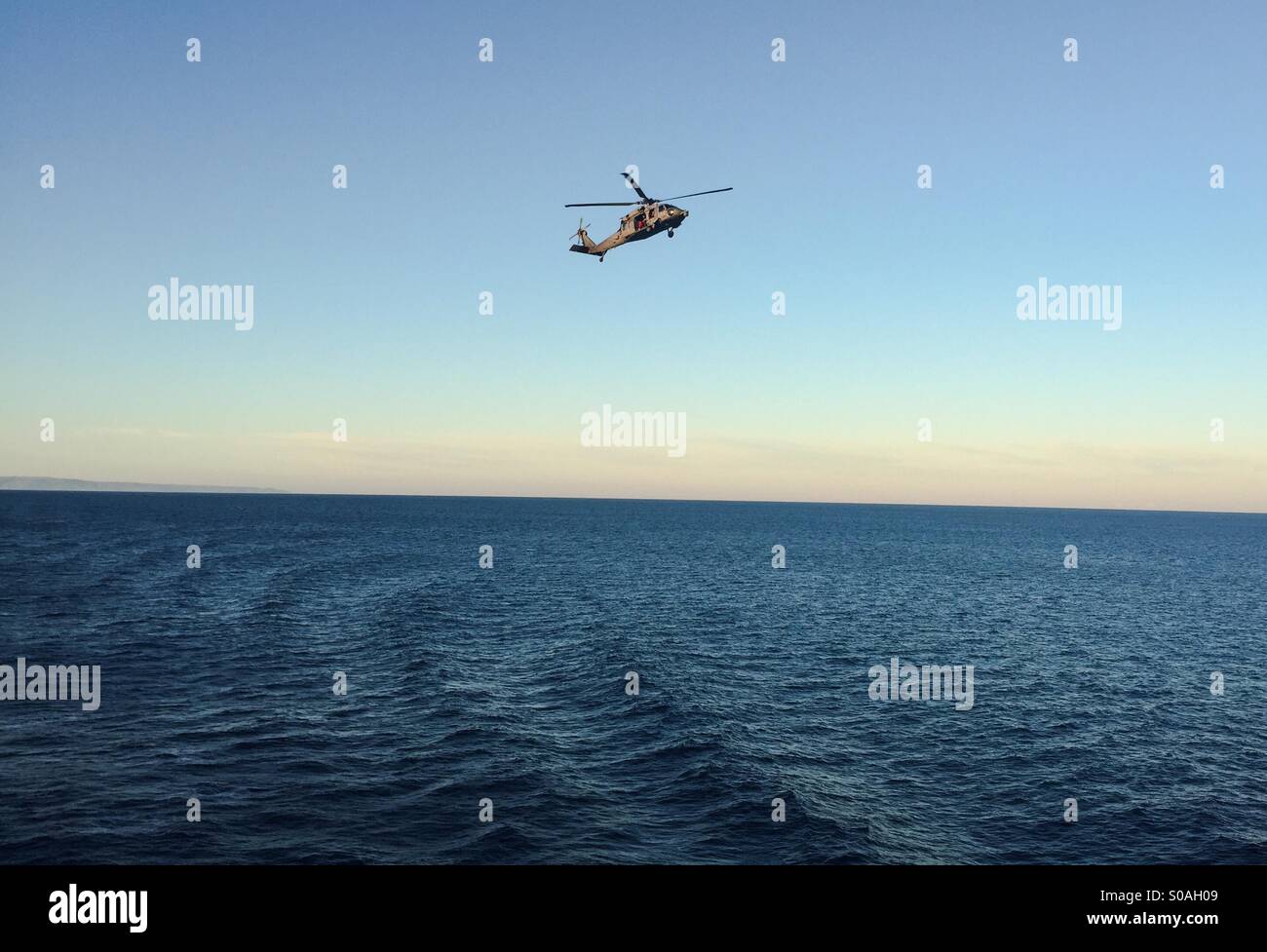 A Navy helicopter flies over the pacific ocean Stock Photo - Alamy