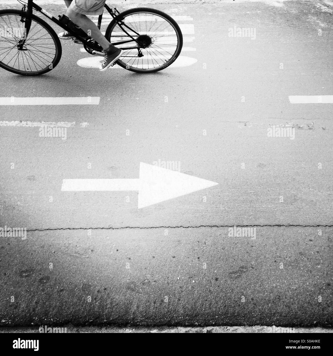 An arrow pointing right with a bike rider going left on a bike path ...