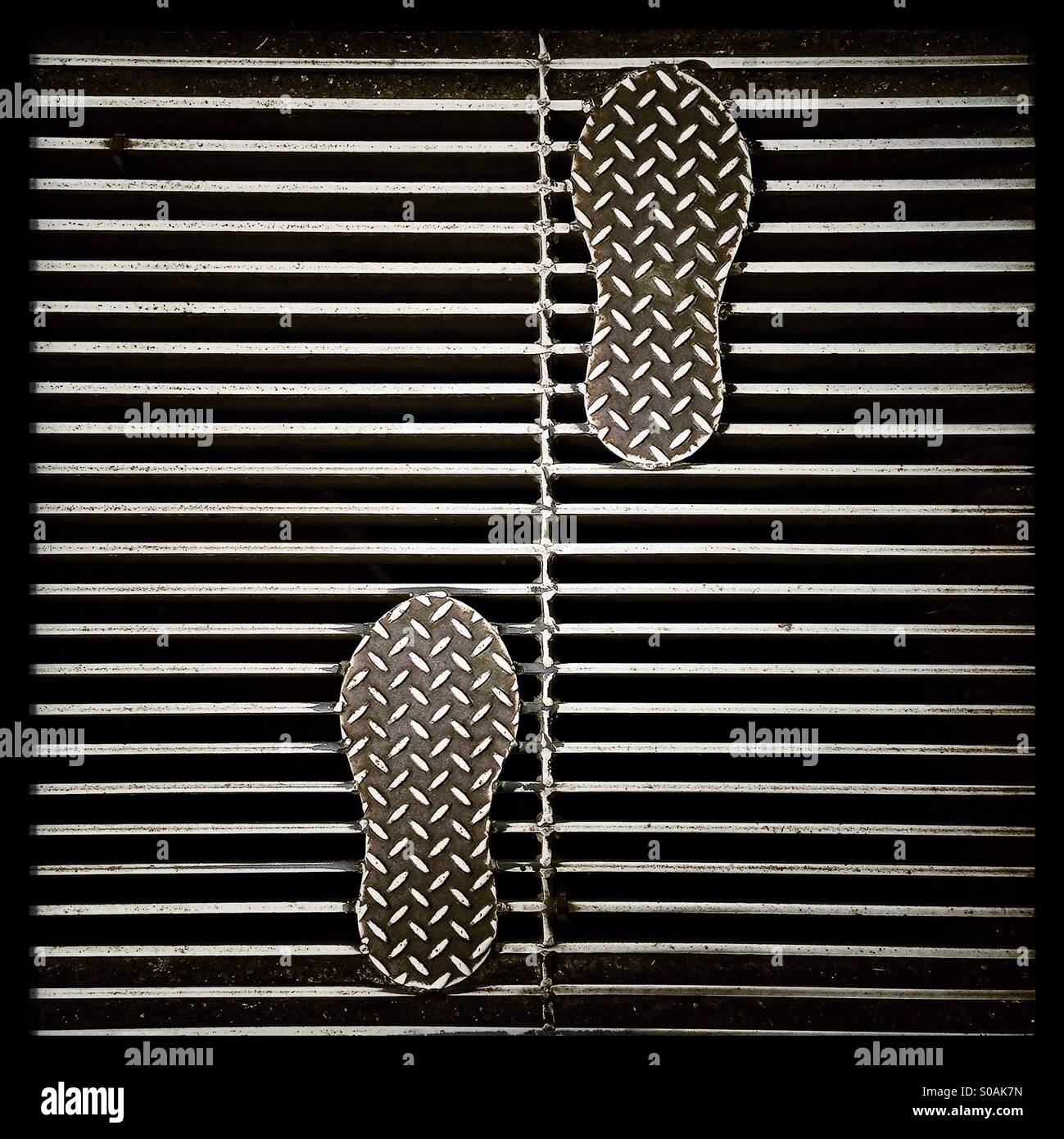 Metal footprints over a sidewalk vent Stock Photo - Alamy