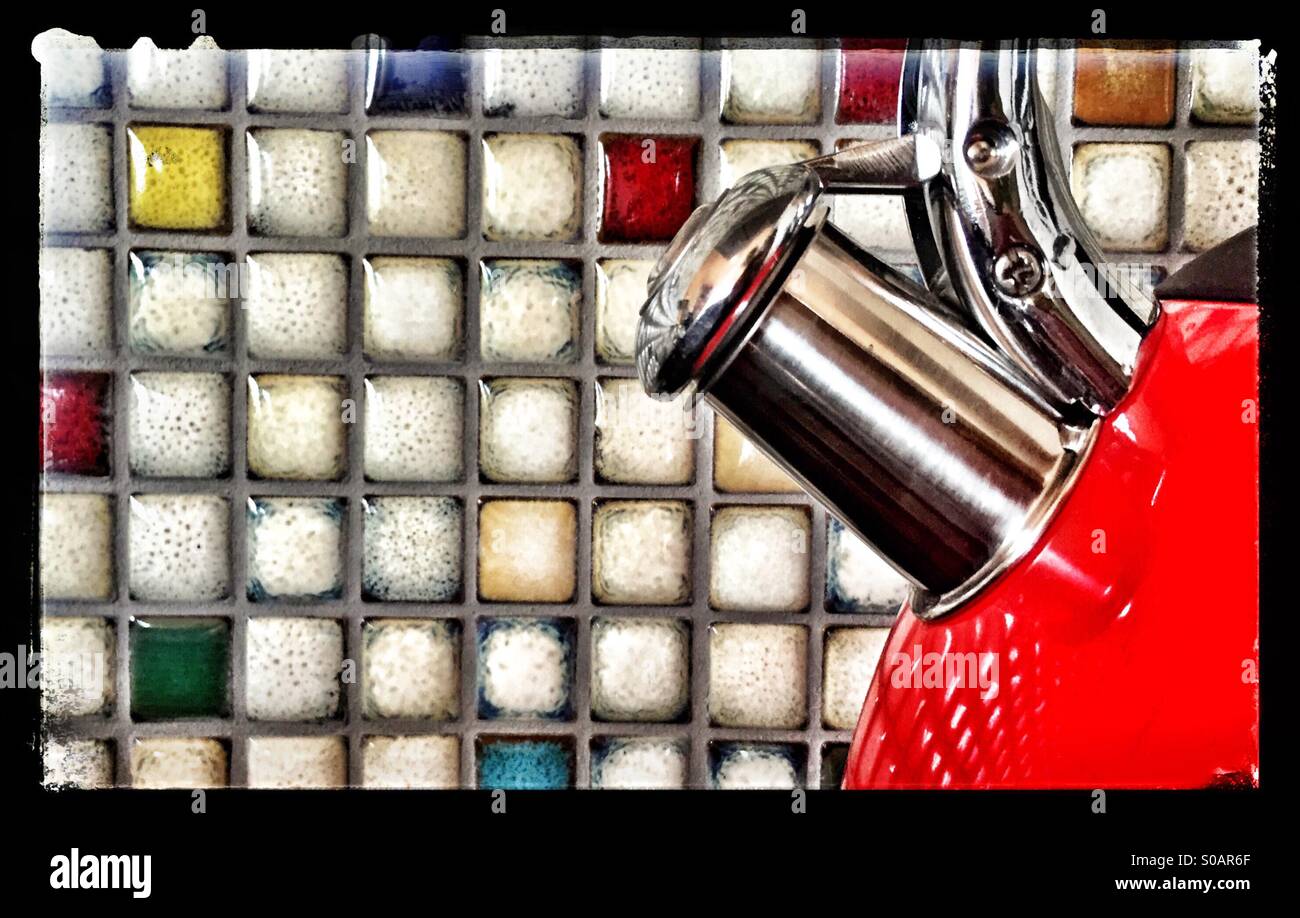Red kettle in front of mosaic tile splash back Stock Photo - Alamy