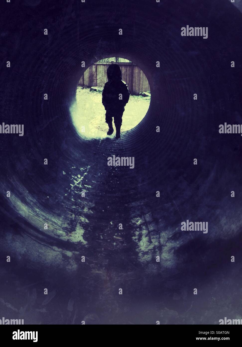 A silhouette of a child walking through large pipe Stock Photo - Alamy