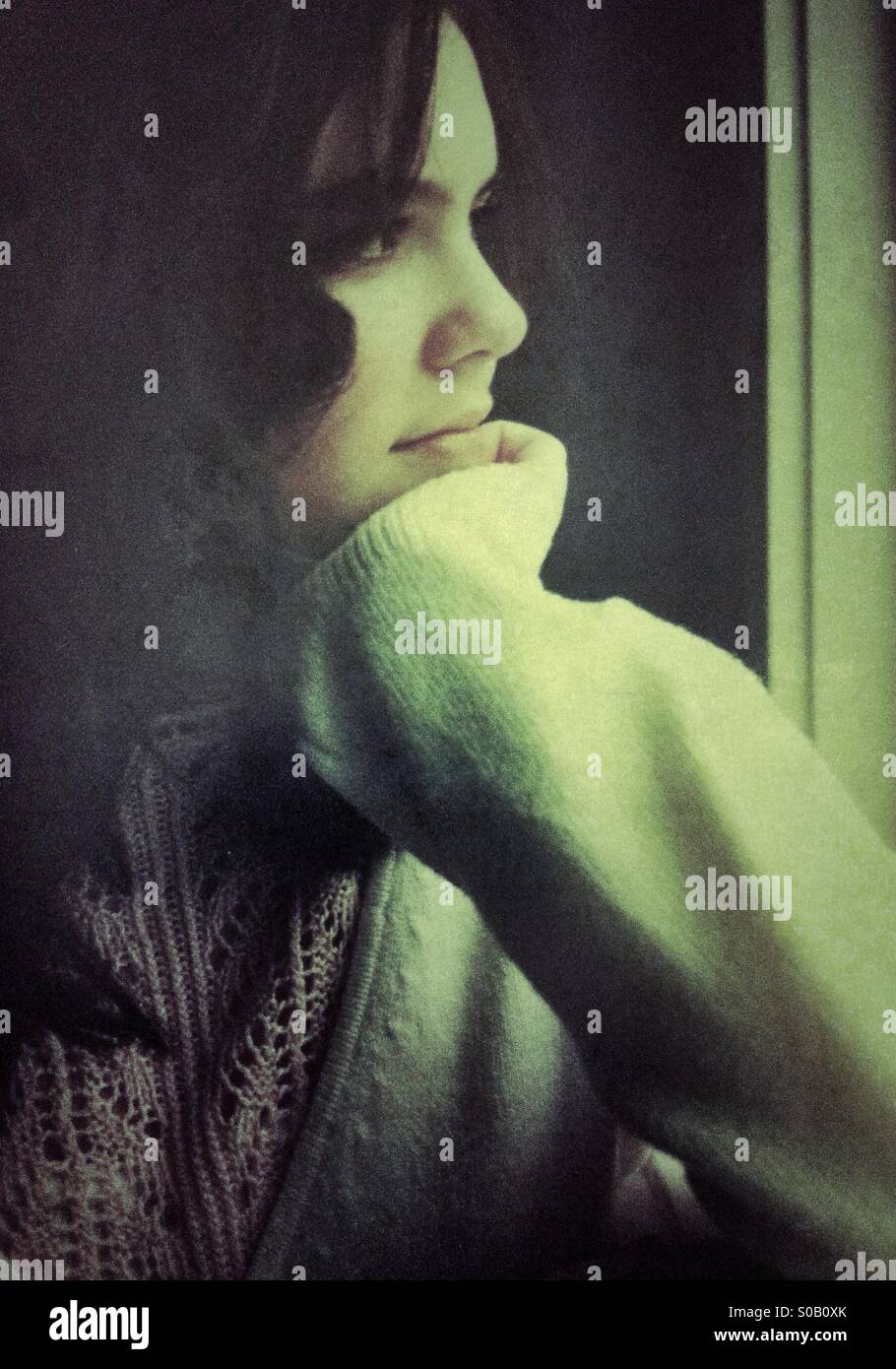 dreamy girl looking out the window supporting her chin on a hand Stock ...