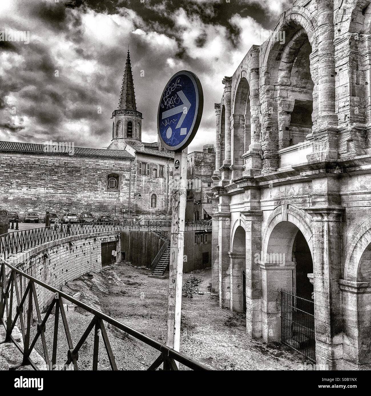 Roman amphitheatre at Arles with blue traffic sign Stock Photo - Alamy