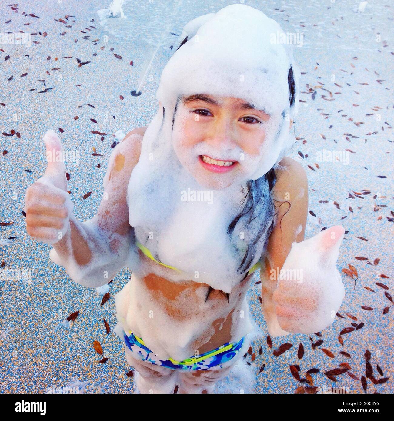 Little girl covered in bubbles at a water park Stock Photo - Alamy