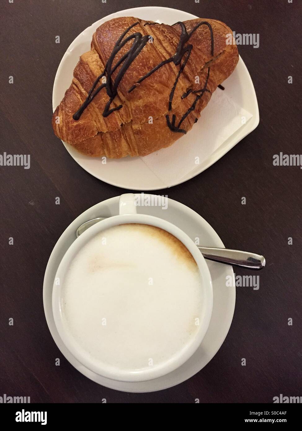 Typical italian breakfast at the bar with a cup of cappuccino and a ...