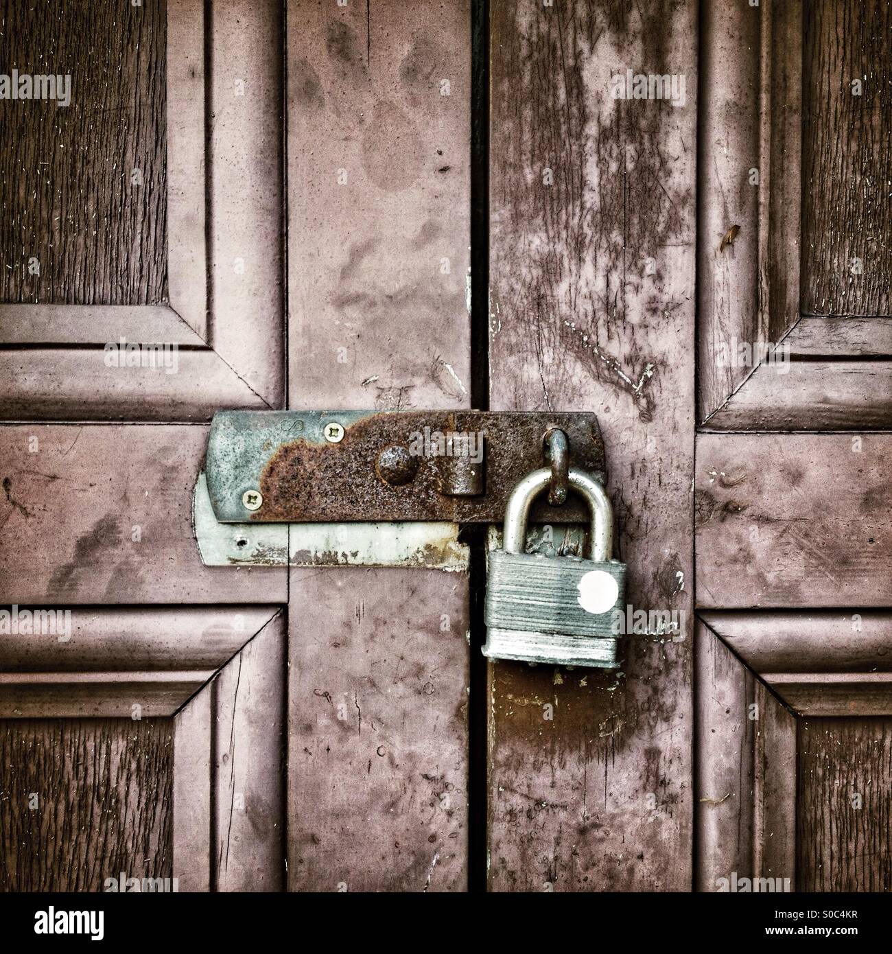 Padlock and rusty hasp on a weathered panel door Stock Photo - Alamy
