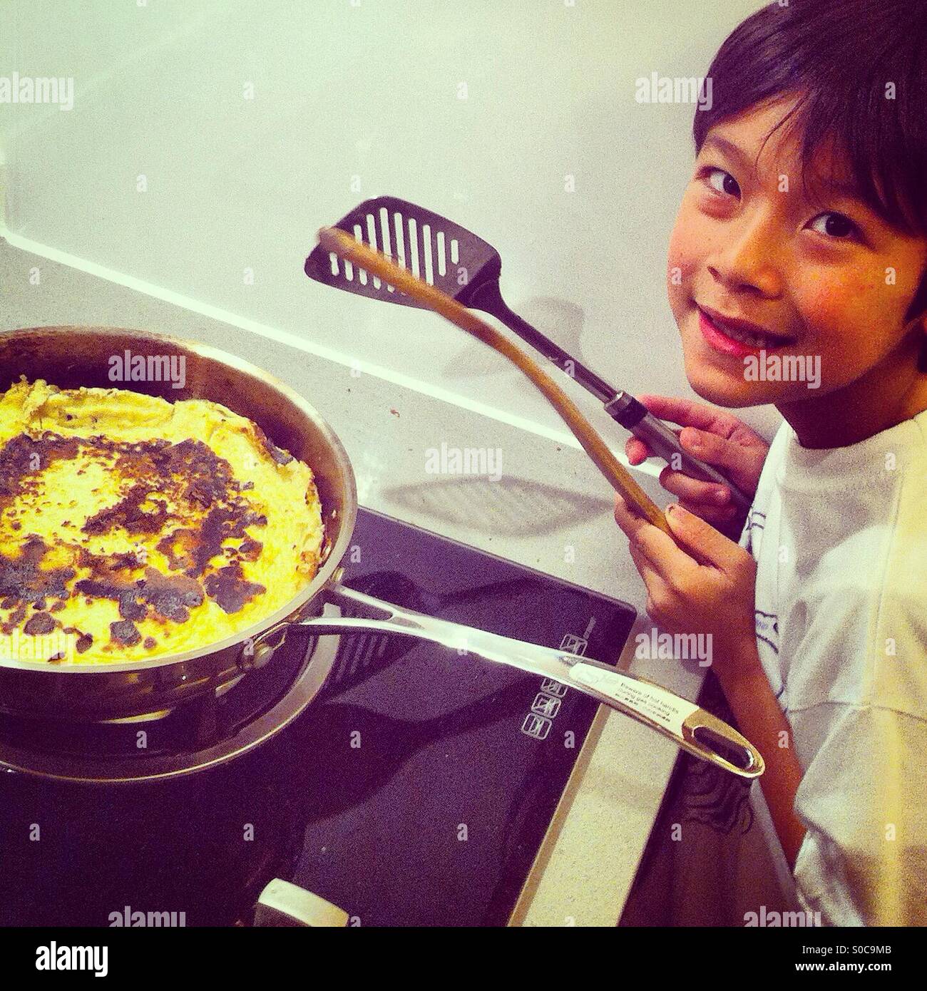 Child cooking pancakes Stock Photo - Alamy