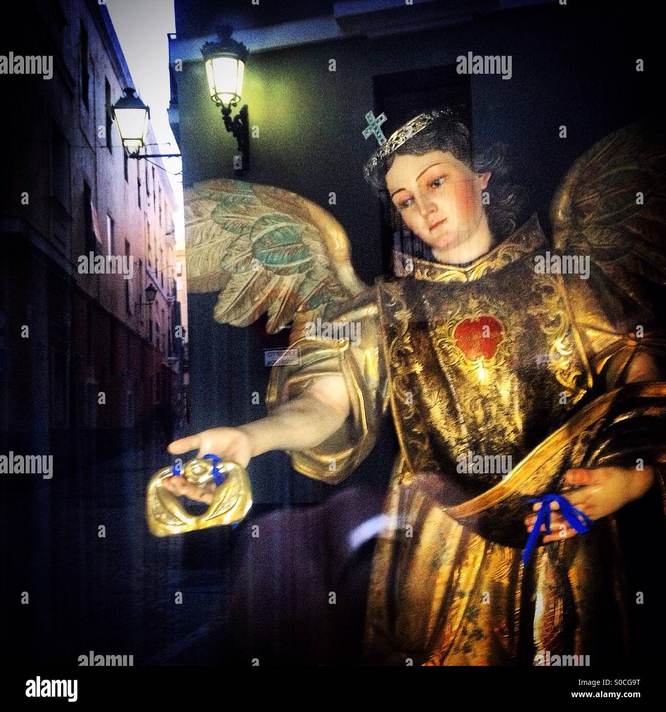 A sculpture of Saint Raphael Archangel with the reflection of a street ...