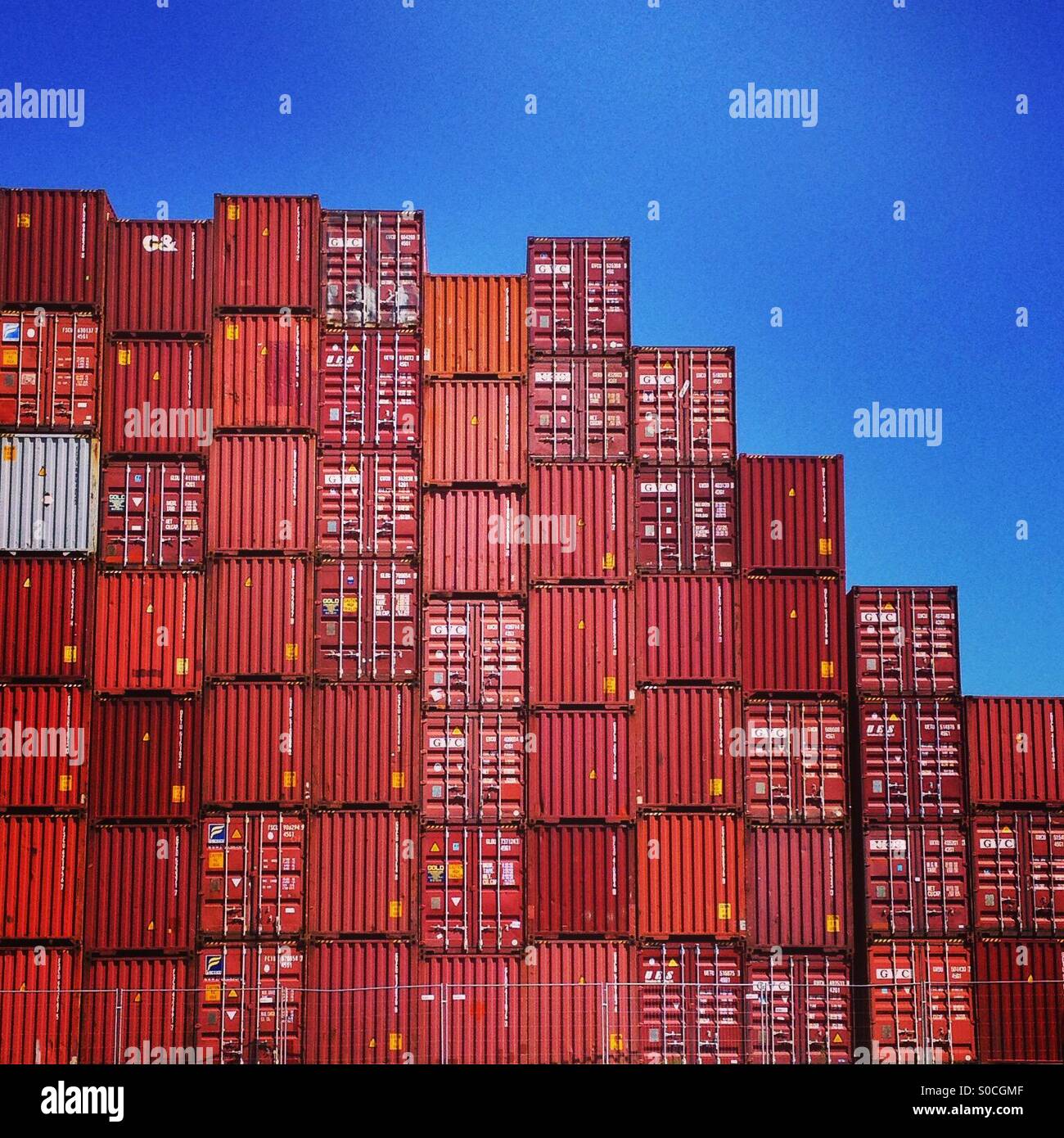 Red containers stacked in the port of Hamburg in Germany, against a ...
