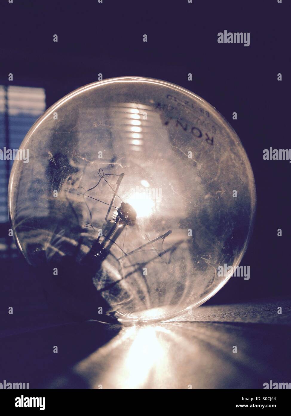Round lightbulb sitting on ledge Stock Photo - Alamy