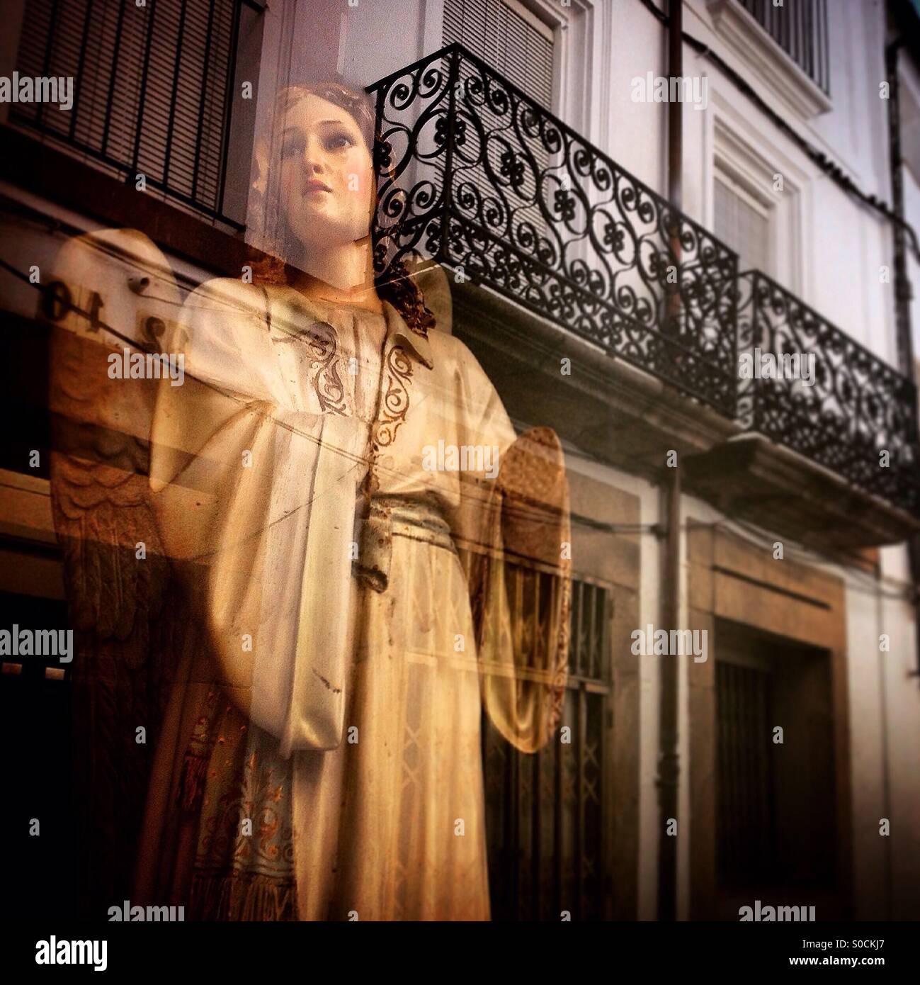 A reflection of a street in a window decorated with an angel in ...