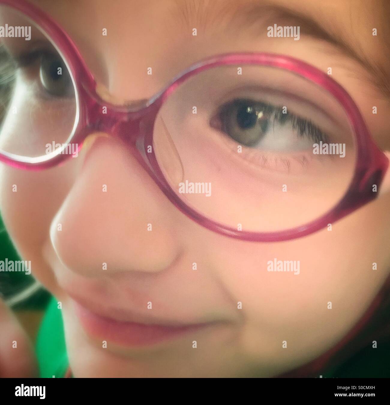 Little girl with round pink glasses looking sideways Stock Photo - Alamy
