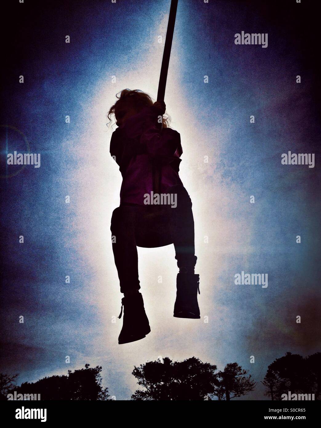 Young girl in silhouette on zip wire Stock Photo - Alamy