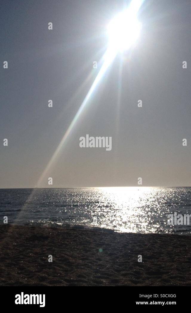 Sun setting on the beach Stock Photo - Alamy