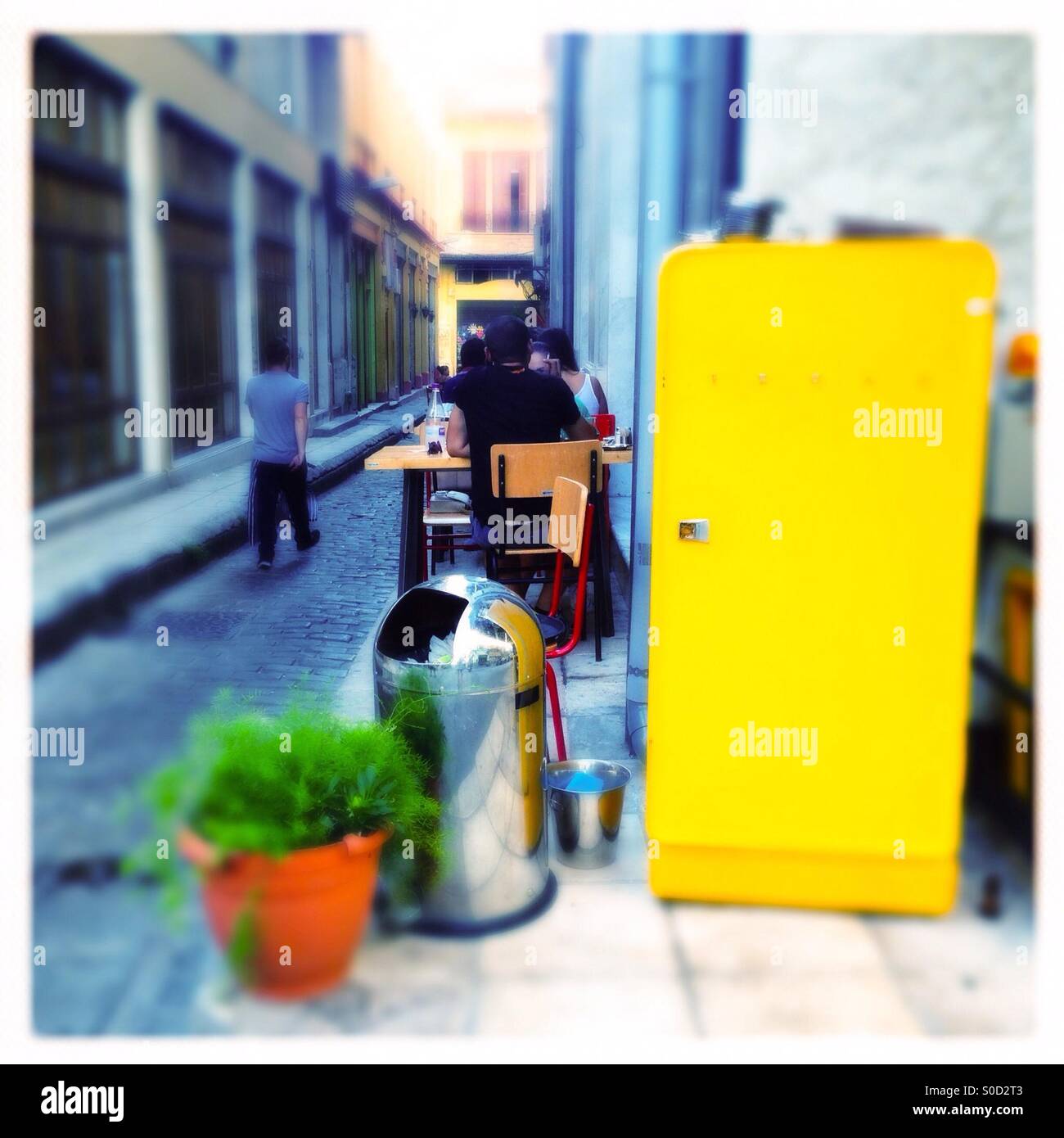yellow refrigerator and trash can at sidewalk cafe in Thessaloniki ...